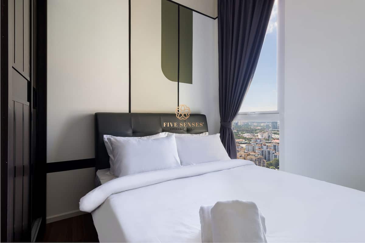 Quarto de hotel com cama, vista da cidade e uma placa na parede.