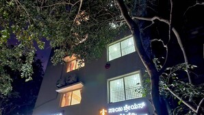 Um edifício com uma placa indicando "Sai Shreyas Residency" e outra placa em outro idioma.