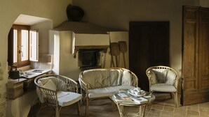 Um quarto aconchegante com móveis de vime, lareira e uma porta de madeira grande.