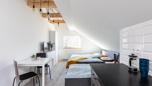 Quarto moderno estilo dormitório, com cama beliche, escrivaninha e cozinha compacta.