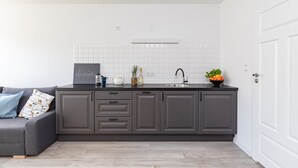 Cozinha moderna com armários cinza, painel de azulejos brancos e torneira preta.