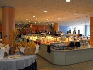 Uma área de buffet com diversos alimentos e utensílios.