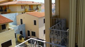 Hotel com várias varandas, telhado em cerâmica e vista para edifícios vizinhos.