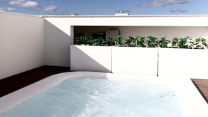 Piscina no terraço com céu azul límpido e algumas nuvens.
