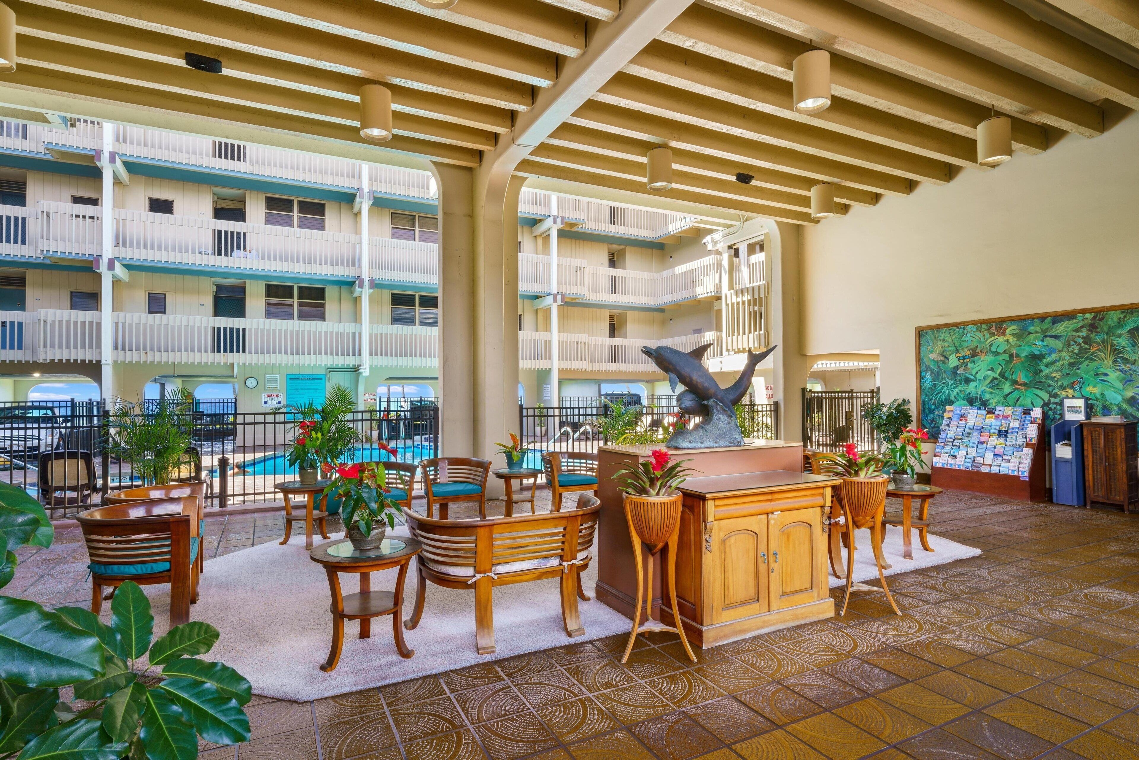 Um espaço amplo e interno com piscina, vários níveis de varandas e diversos tipos de assentos.