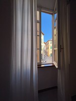 Quarto com janela que dá para a rua.