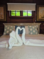 Quarto de hotel com uma cama, uma janela com persianas e um quadro na parede.