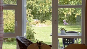 Quarto com vista para um jardim através de portas francesas.