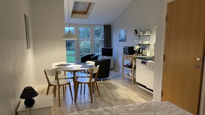 Um espaço compacto para viver, com área de refeições, cozinha compacta e cama.