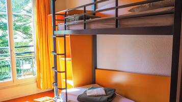 Quarto com beliche, janela e cortinas.