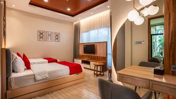 Quarto de hotel moderno com cama, escrivaninha, poltrona, televisão e uma grande janela.
