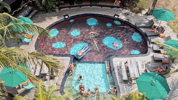 Uma área de piscina com espreguiçadeiras e guarda-sóis.