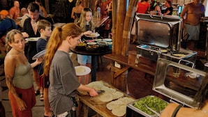 Buffet com diversas opções de comida e um espaço com grelha.