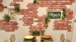 Uma mesa de jantar com quatro cadeiras, um cardápio e uma placa na parede.