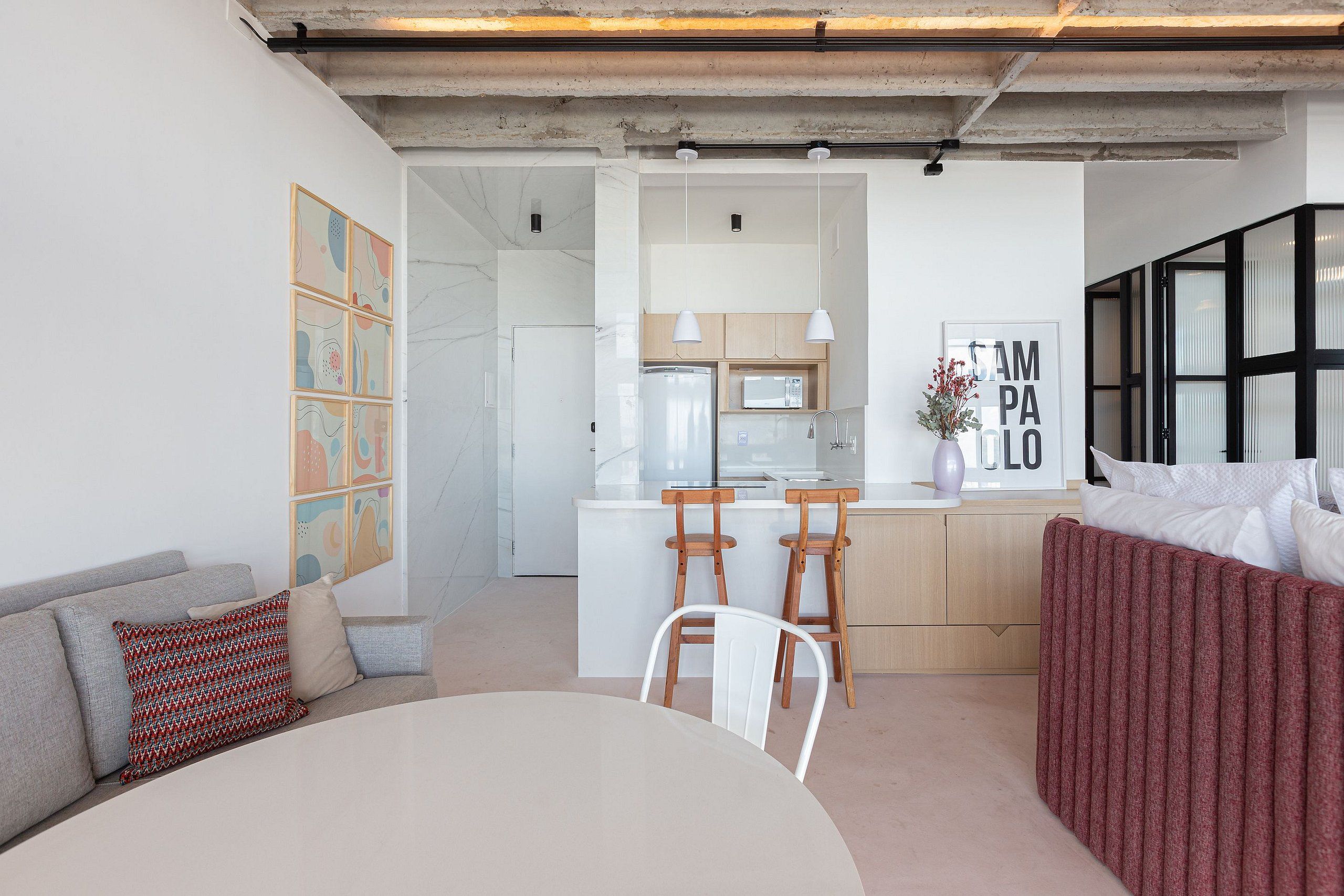 Um espaço moderno para viver, com cozinha, mesa de jantar e sofá.