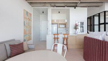 Um espaço moderno para viver, com cozinha, mesa de jantar e sofá.