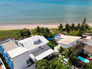 Na praia, areia branca, guarda-sóis, toalhas de praia 