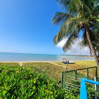 Perto da praia, areia branca, guarda-sóis, toalhas de praia 