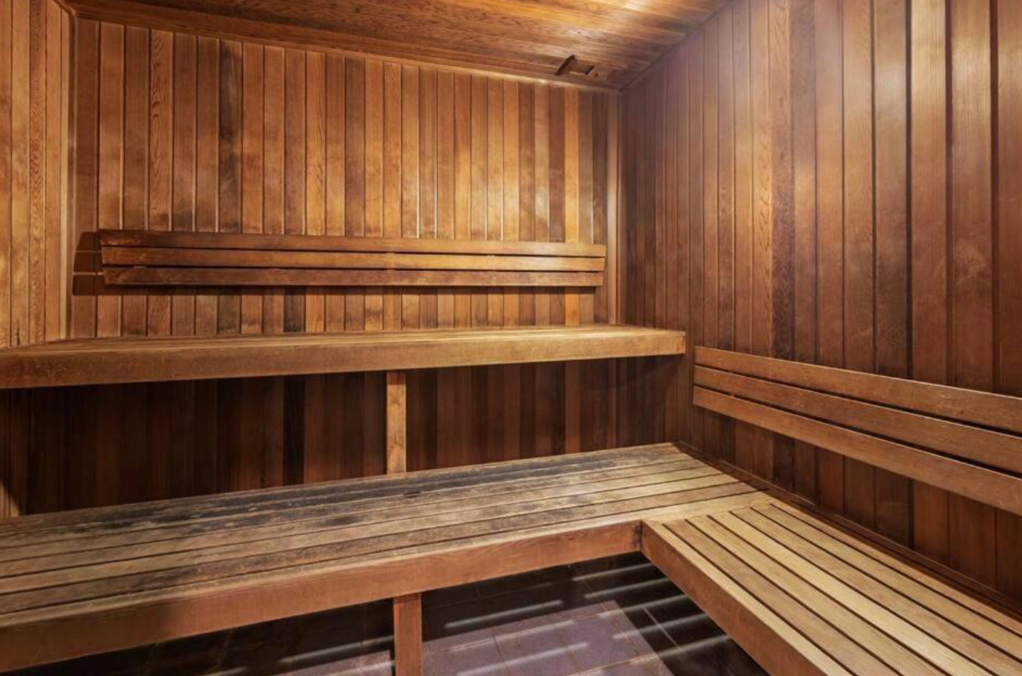 Uma sauna com bancos e paredes de madeira.