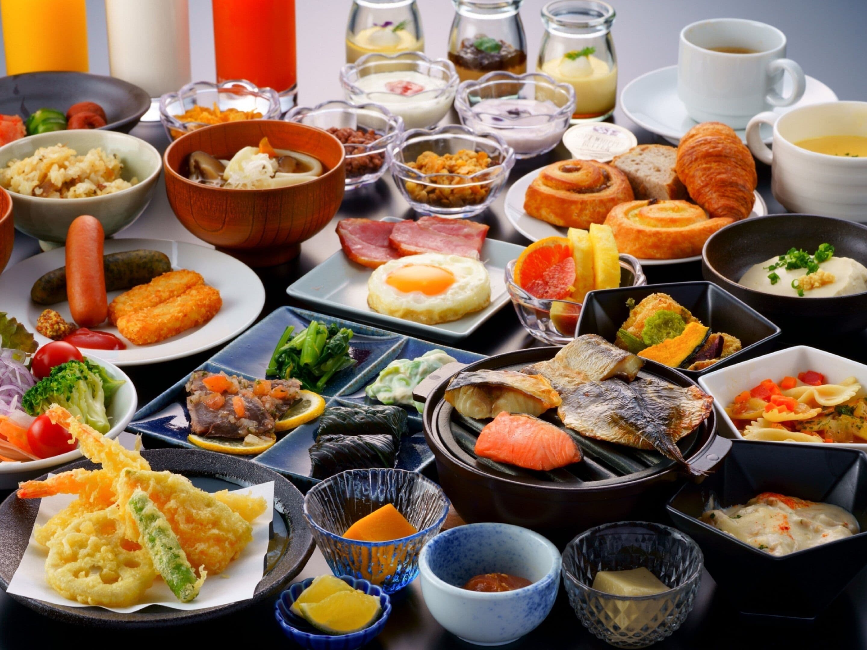 Diversos pratos, incluindo sushi, sashimi e outras especialidades da culinária asiática, dispostos sobre uma mesa.