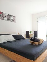 Um quarto com uma cama, uma escrivaninha e uma cadeira.