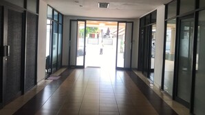 Um corredor com portas de vidro deslizantes que dão para uma área externa.