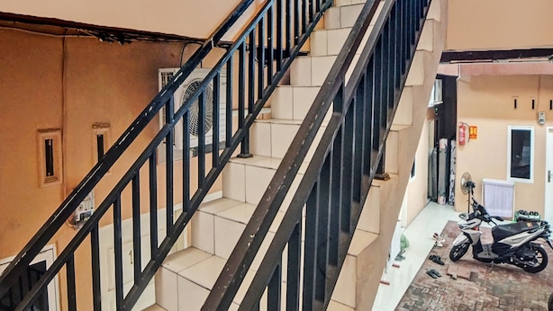 Uma escadaria com grades pretas que desce para um nível inferior.