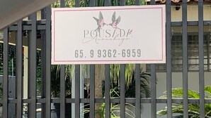 Placa com o nome 'POUSADA Aconchego' e um número de telefone.