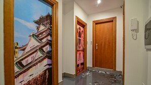 Um corredor com um mural arquitetônico tradicional, uma porta de madeira e um piso com um logotipo.