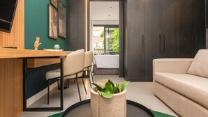 Uma sala de estar moderna com um sofá, um espaço de jantar com mesa e cadeiras, e um armário grande e escuro.