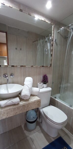 Uma casa de banho moderna com lavatório, sanita e chuveiro.
