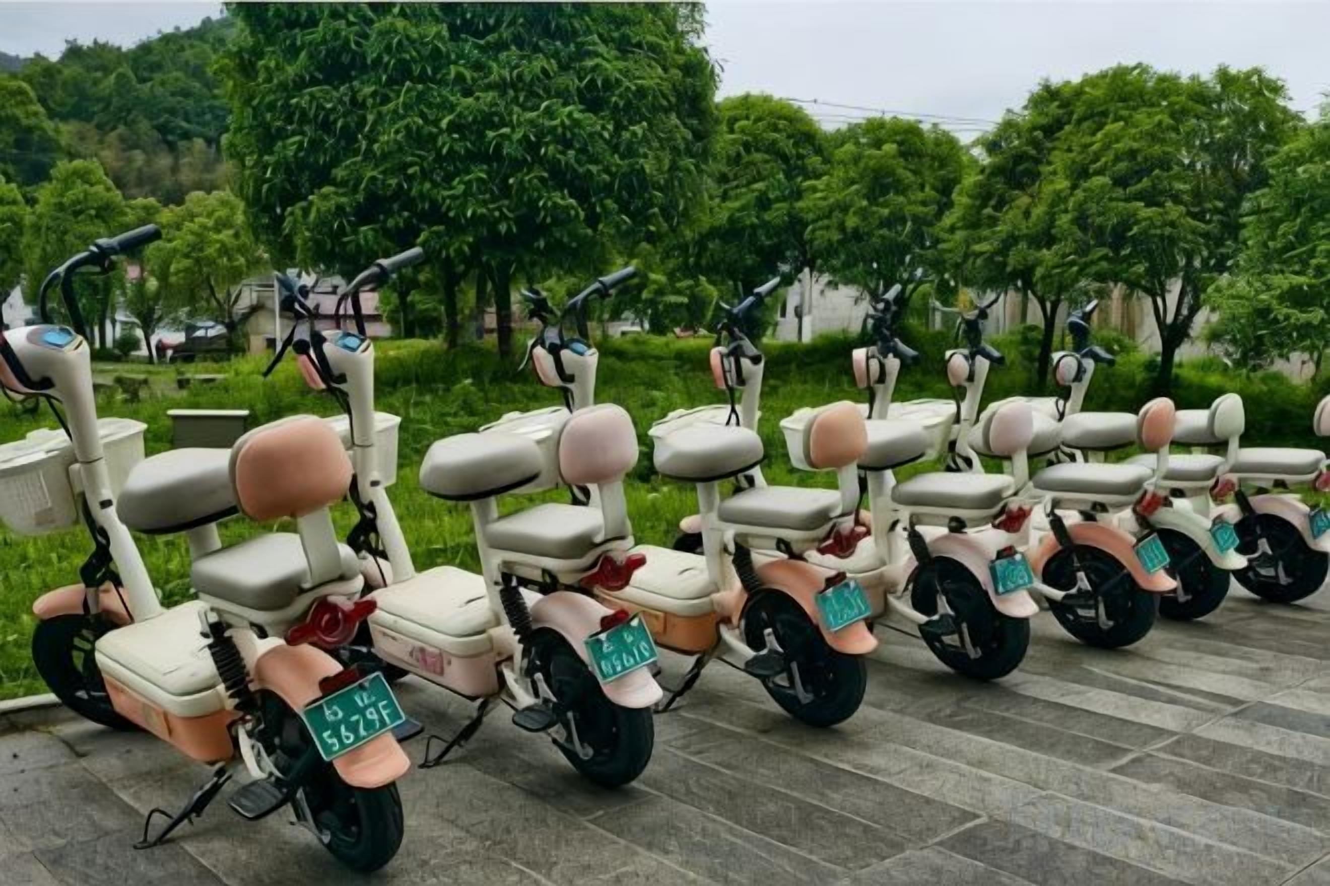 Uma fileira de scooters estacionadas em piso pavimentado.
