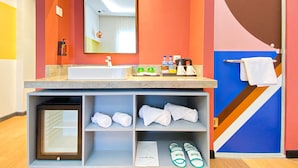 Uma casa de banho moderna com uma grande pia, espelho e prateleiras para toalhas e artigos de higiene pessoal.