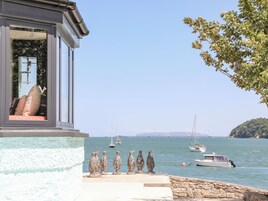 Um edifício com fachada de pedra e vista para o mar, com barcos.