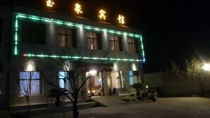 Um edifício com letreiros iluminados e uma entrada bem iluminada.