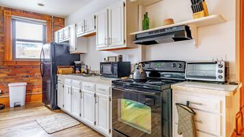 Um frigorífico/congelador grande, um micro-ondas, um forno