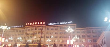 Um edifício grande com vários andares e uma placa bem visível do Hotel Labueng Civil Aviation.