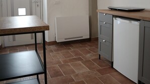 Uma cozinha com bancada, lava-louças e porta branca com janelas quadradas.