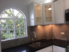 Uma cafeteira/bule, mesas de jantar 