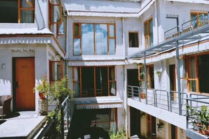 Edifício com várias andares, varandas, janelas e áreas de estar ao ar livre.