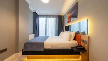 Quarto de hotel com cama, mesa de cabeceira e telefone.
