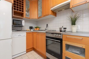 Um micro-ondas, uma máquina de lavar louça, utensílios de cozinha 