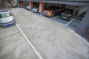 Garagem de estacionamento com vários carros estacionados em vagas demarcadas.