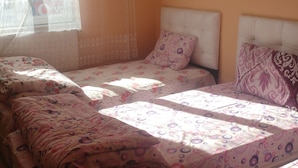 Quarto com duas camas, cada uma com roupa de cama estampada com flores.