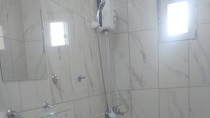 Casa de banho com lavatório branco, sanita e zona de duche.