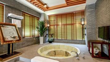 Uma área de spa com hidromassagem, ripas de madeira nas janelas e um painel informativo emoldurado.