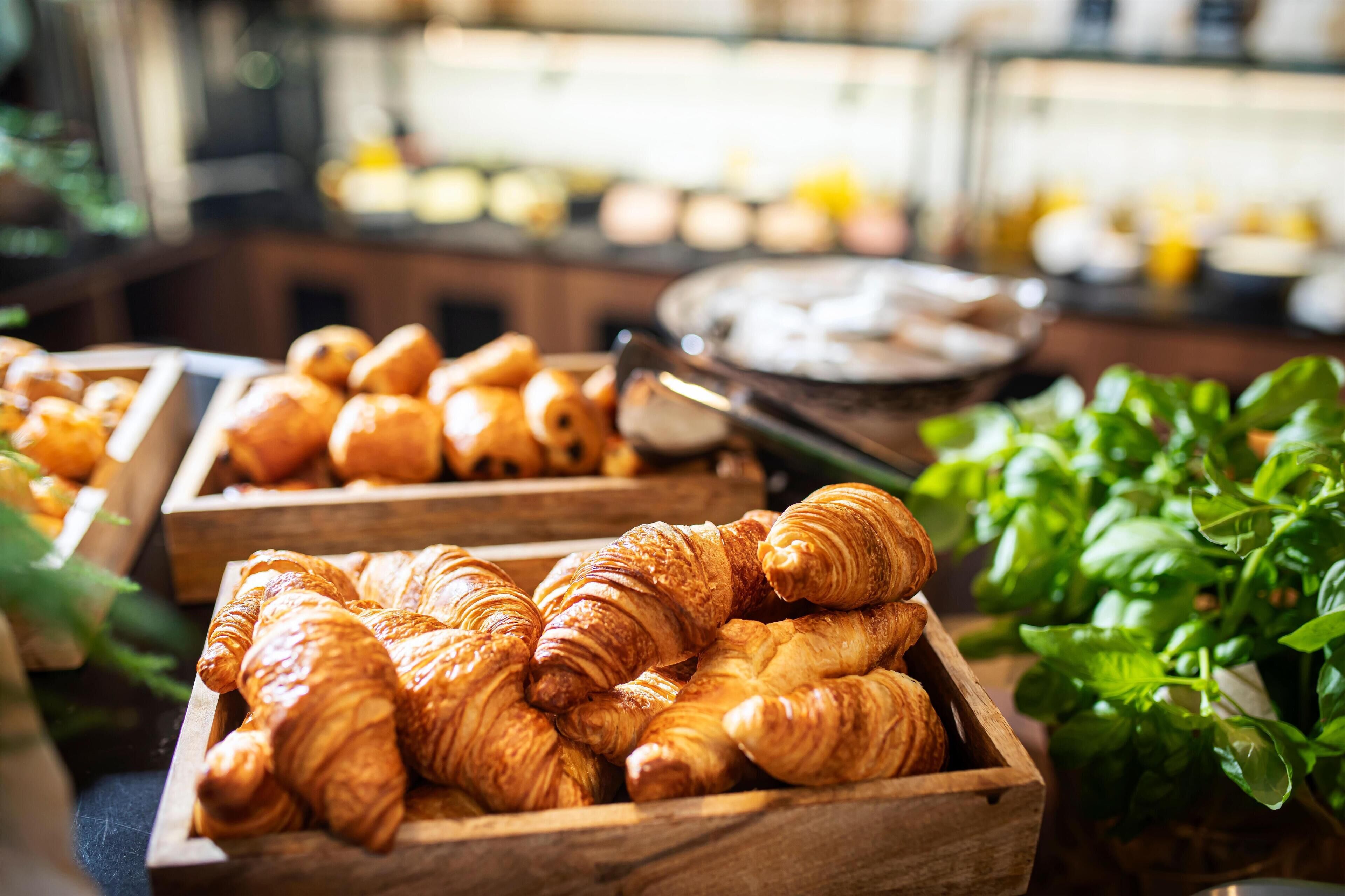 Exposição de croissants em caixas de madeira.