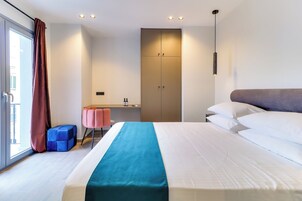 Quarto de hotel moderno com uma cama grande, uma escrivaninha e um guarda-roupa.
