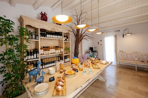 Disposição de buffet com diversos pratos e seleção de vinhos.