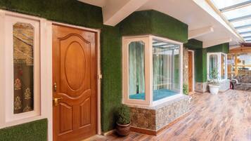 Um interior moderno com porta de madeira, detalhes em parede verde e uma parede de pedra decorativa.